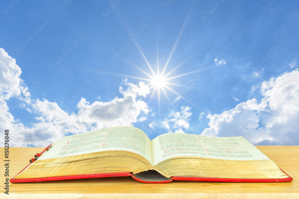 Open bible with sun and blue sky Stock Photo | Adobe Stock