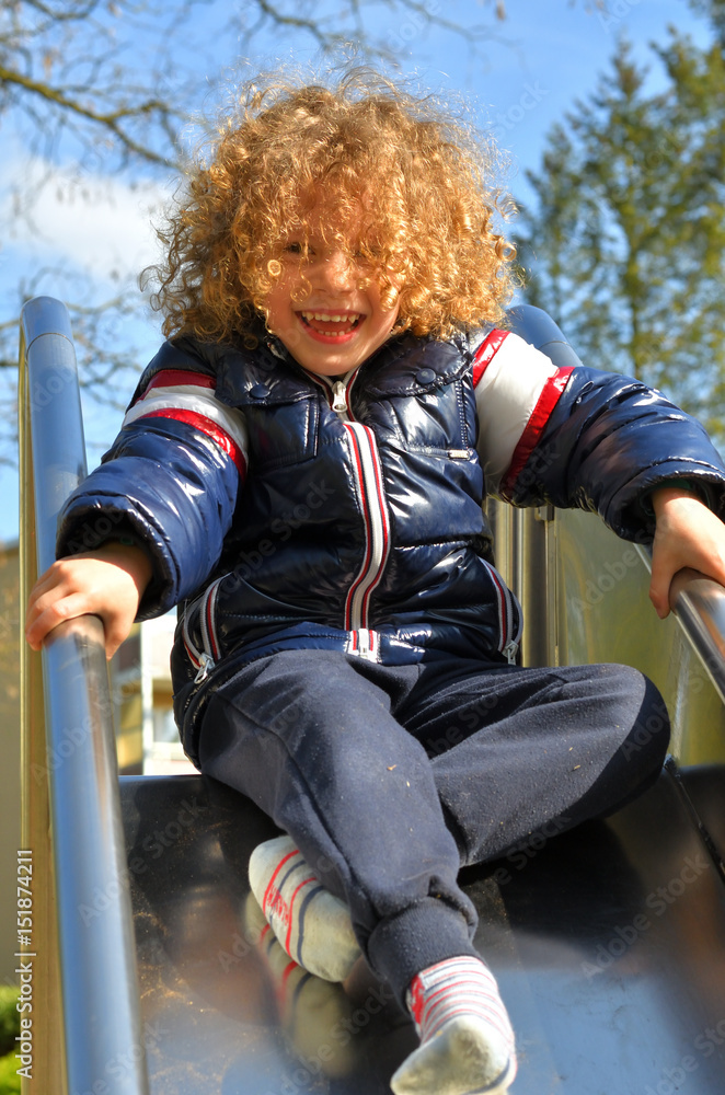 Kind spielt auf Rutsche Stock-Foto | Adobe Stock