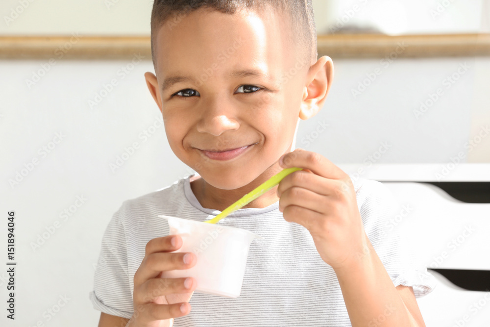 Cute African American boy eating yogurt at home Stock Photo | Adobe Stock