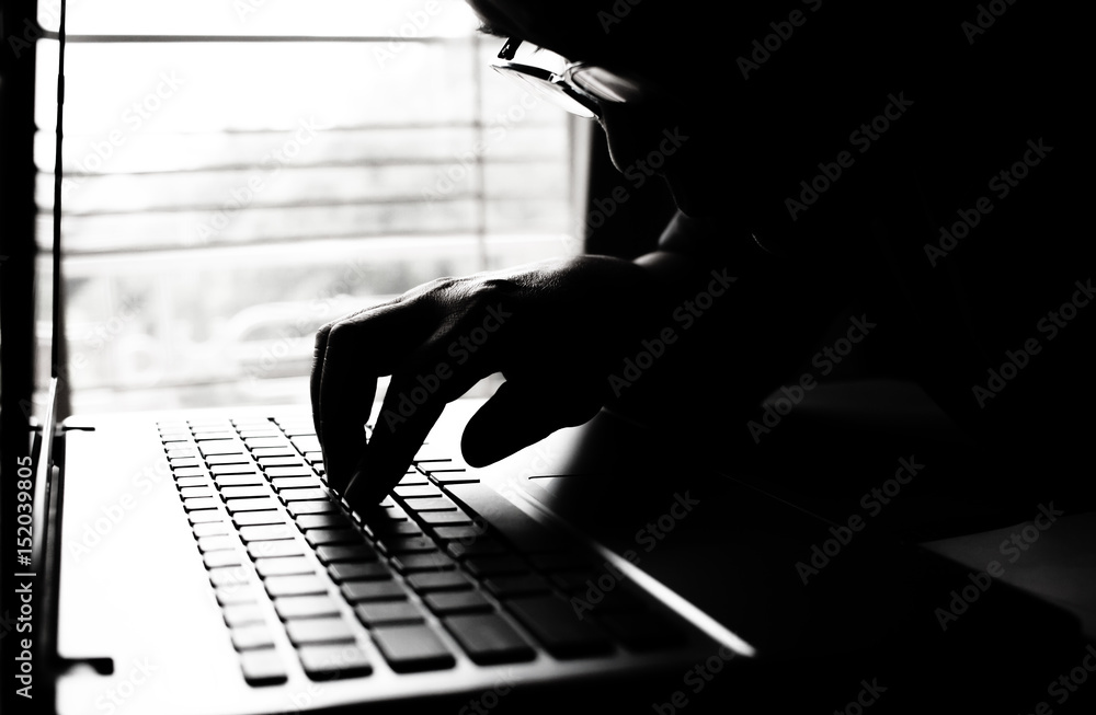 silhouette black and white of anonymous hacker typing on keyboard of ...