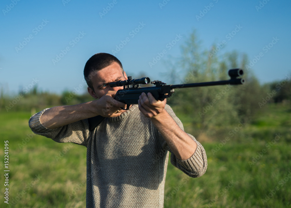 The man takes aim at the target with a sniper strikeball rifle ...