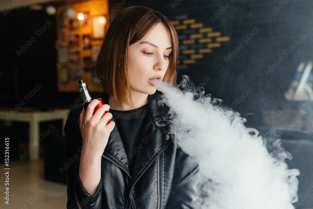 Portrait of cute young vaping girl. Vapor concept. Vaping e-Cigarette ...