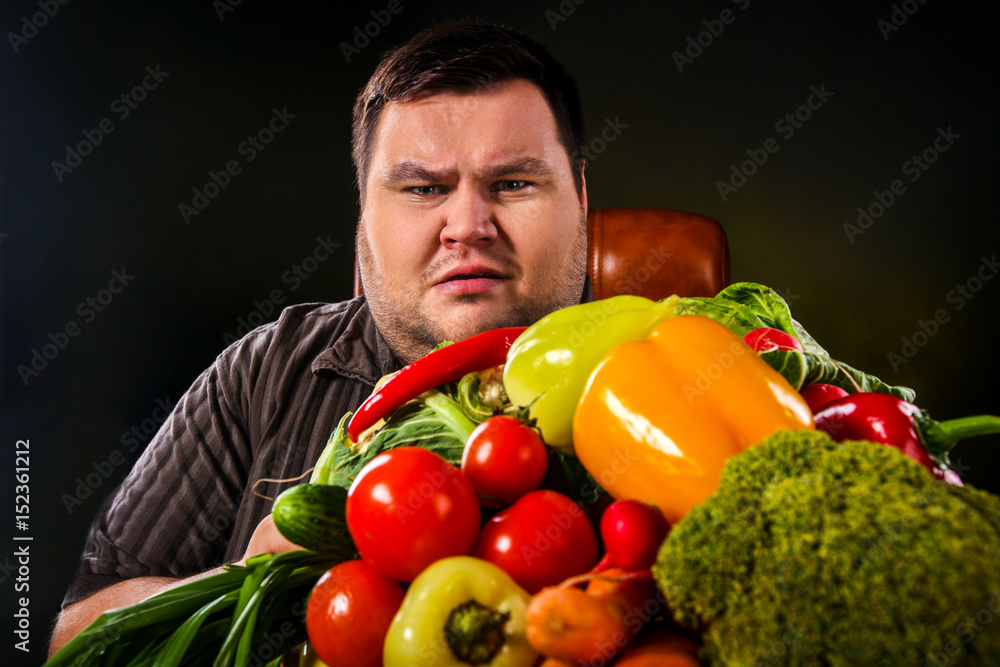 Diet fat man eating healthy food with vegetables cauliflower and sweet ...