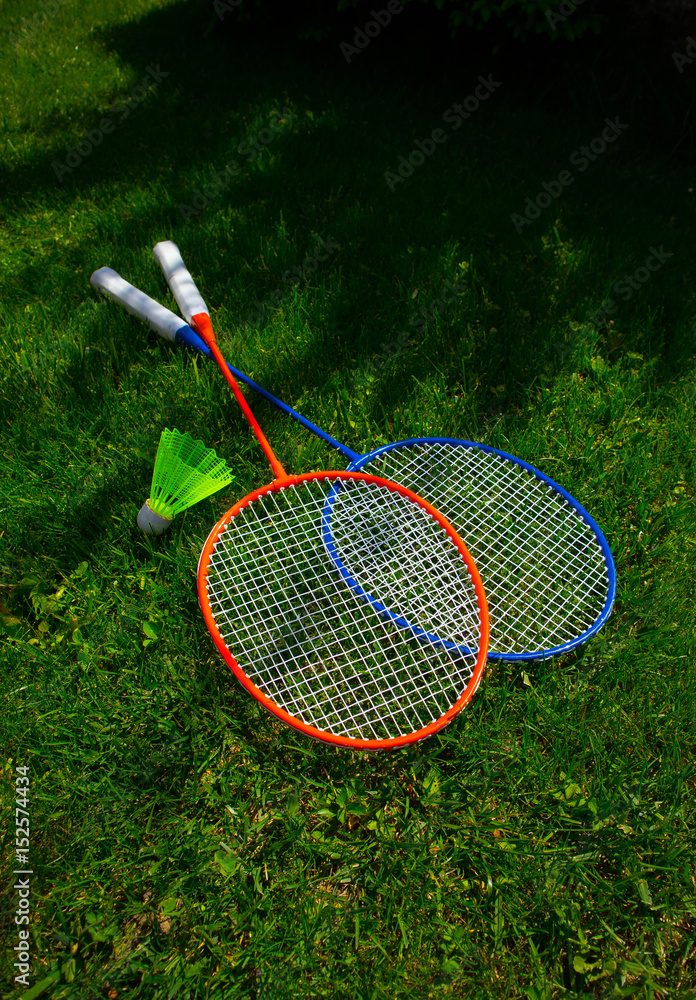 Two badminton racket on the sunny bright grass green fresh background ...