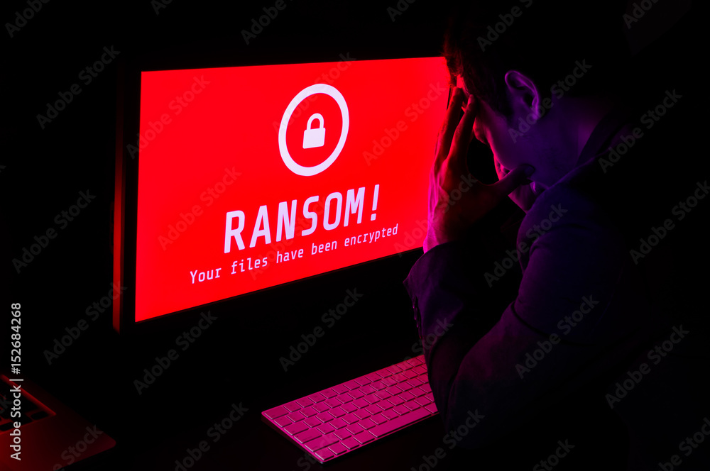 Computer screen with ransomware attack file encrypted alerts in red and a man in suit get stress ...