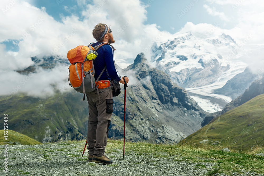 hiker with backpack stands on the trail in the Apls mountains. Trek ...