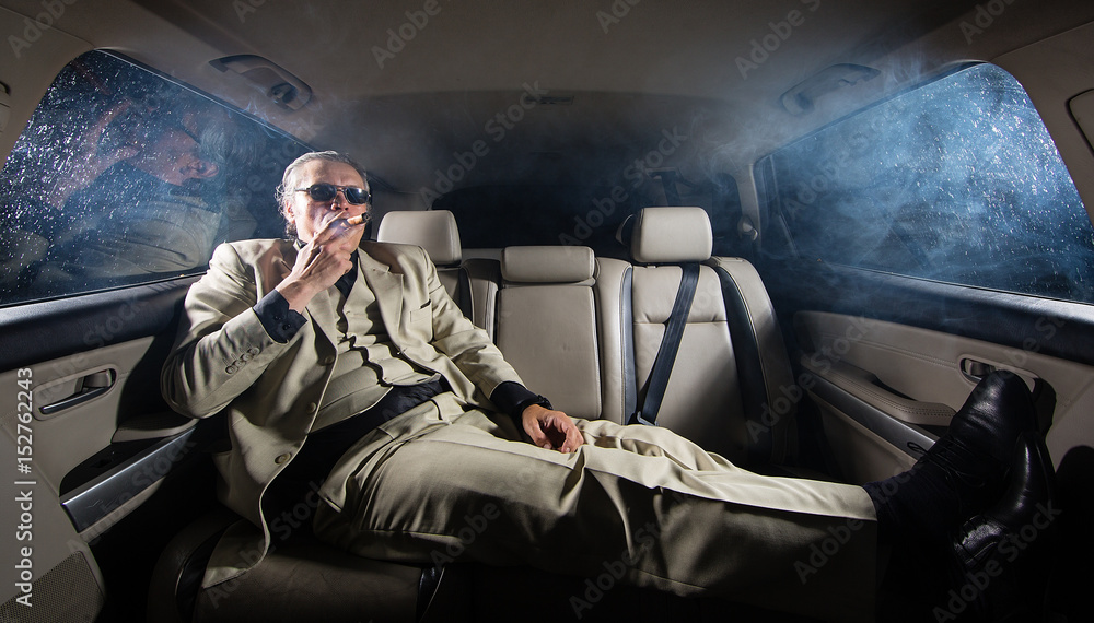A rich man in a white suit and a cigar in the car, a limousine Stock ...