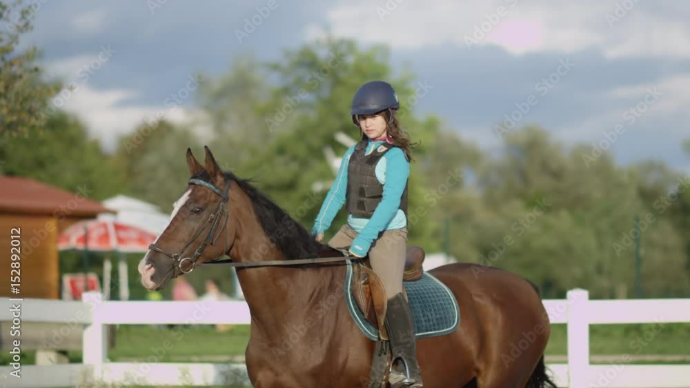 SLOW MOTION CLOSE UP: Young girl horseback riding beautiful chestnut ...