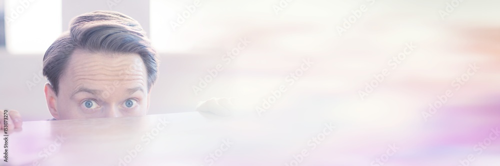 Nervous businessman peeking over desk Stock Photo | Adobe Stock