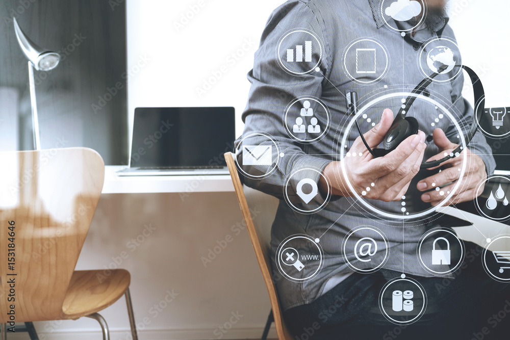 Man using VOIP headset with digital tablet and laptop computer as ...