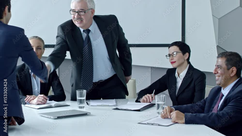 HR managers sitting around meeting table while senior CEO standing up ...