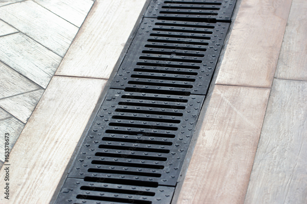Rainwater drainage system on a sidewalk Stock Photo | Adobe Stock