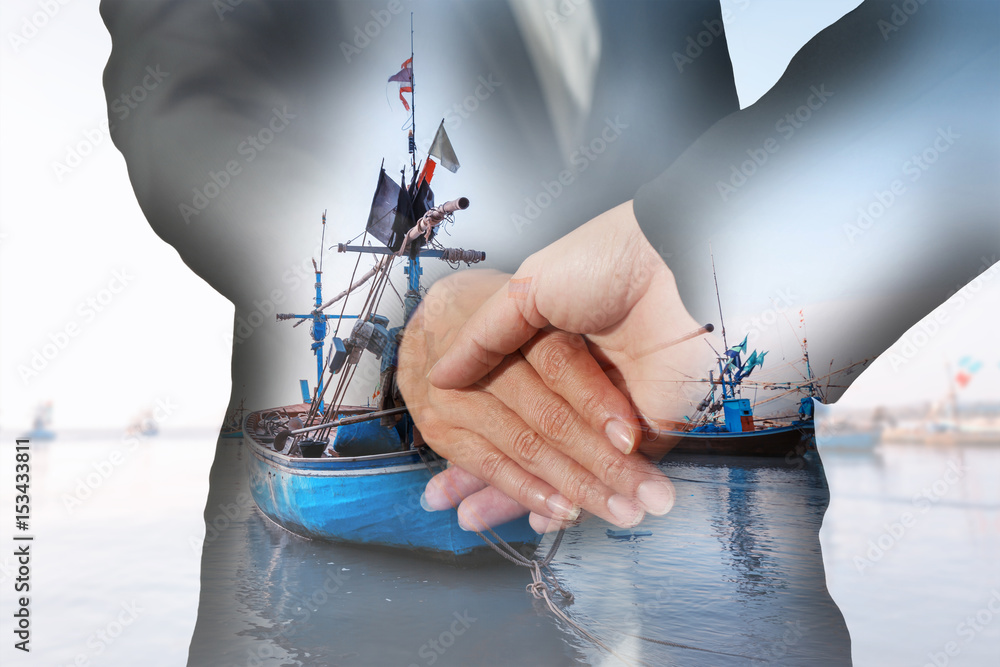 Double exposure of handshake, fishing boat and sea as business ...