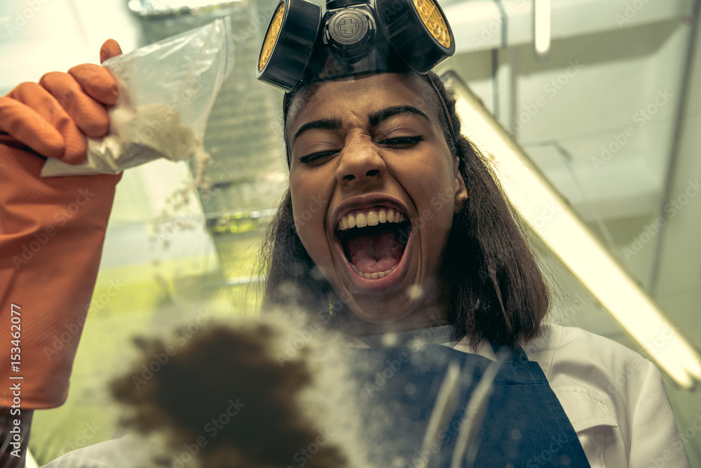 young girl chemist in personal protective equipment working with drugs ...