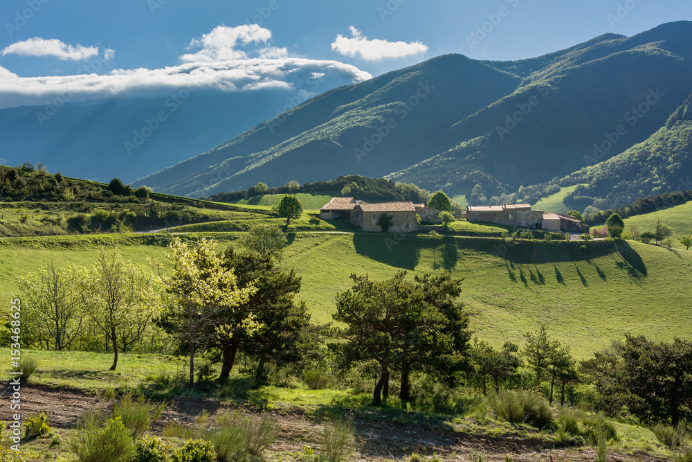 French countryside. Typical old farm with mountains in the background ...