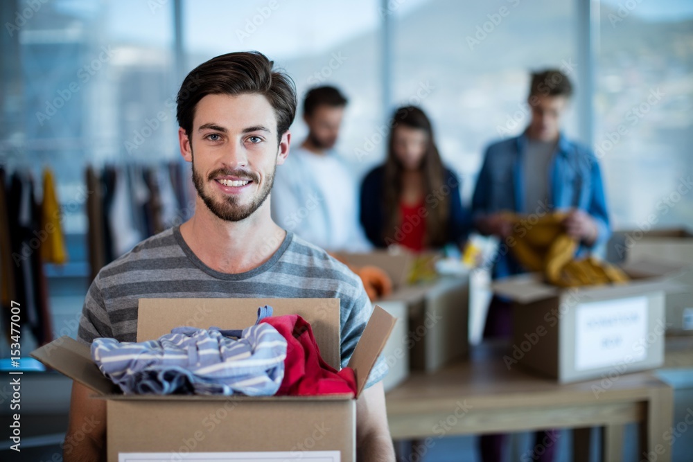 Smiling man holding a donation box in office Stock Photo | Adobe Stock