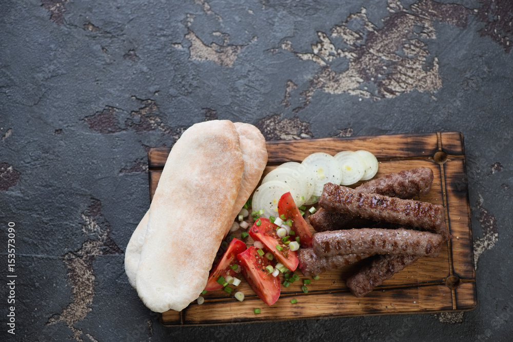 Barbecued cevapcici sausages served with pita bread, sliced fresh ...