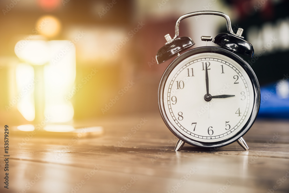 3 o'clock time retro clock on wood table with sun light background ...