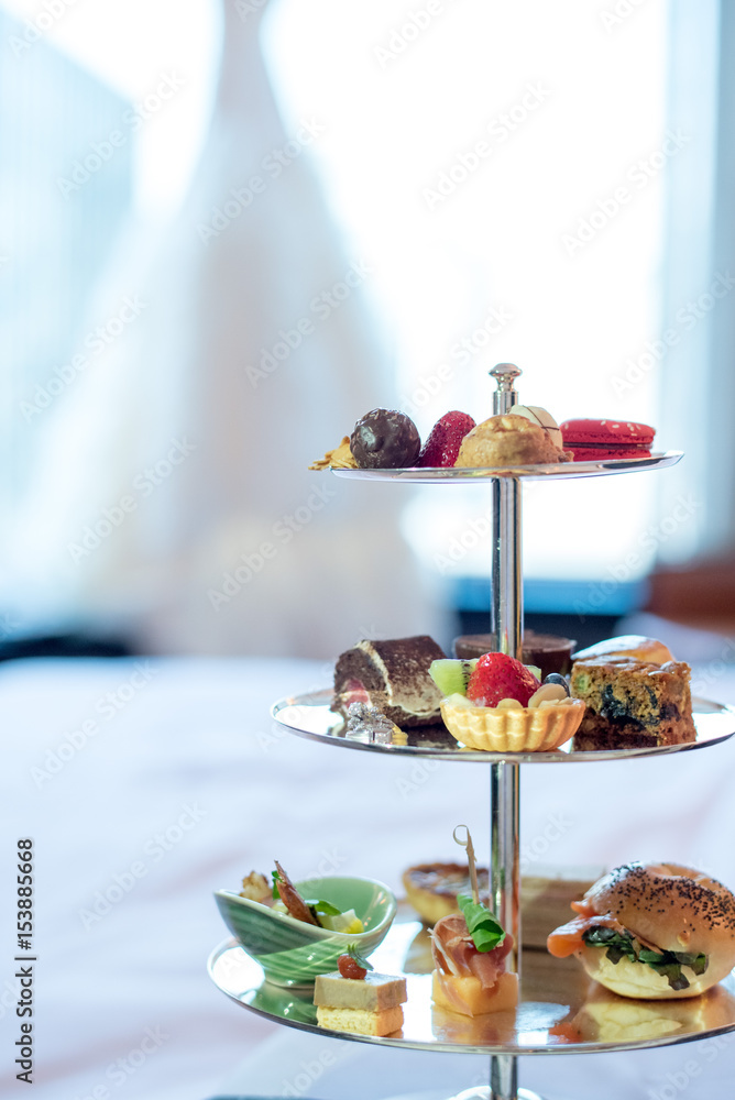 Finger Food appetizer in three tier stand with bride dress background ...