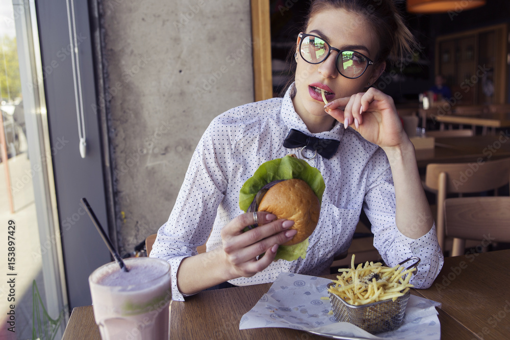 Beautiful caucasian young woman eating lunch fast food fried potato ...