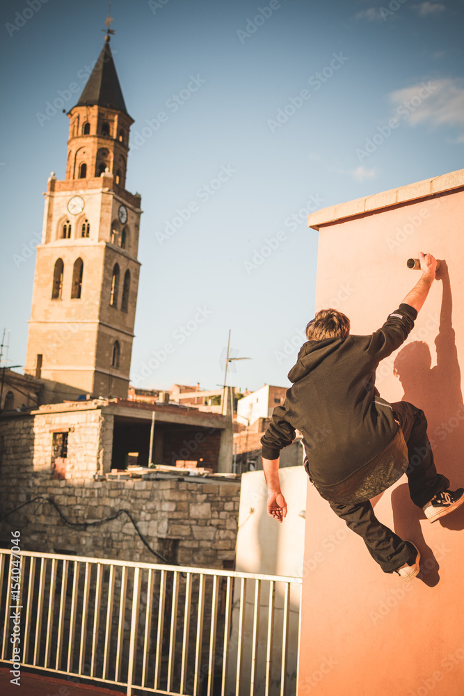 Chico joven saltando en la azotea al atardecer Stock Photo | Adobe Stock