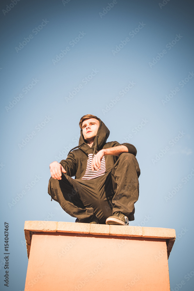 Chico joven saltando en la azotea al atardecer Stock Photo | Adobe Stock