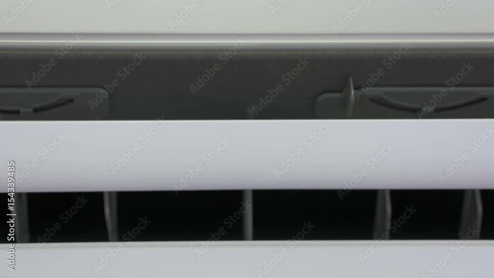 Adjusting the air flow direction in a split air conditioner. Closeup of ...