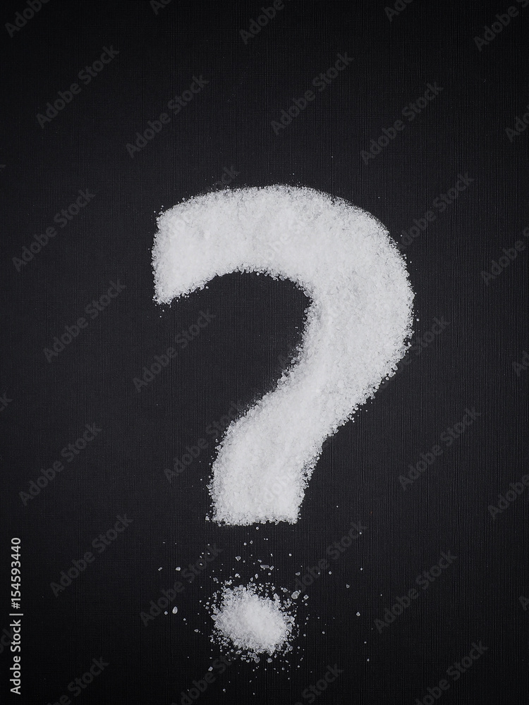 Salt spilled in the shape of question mark on black background. Pros ...