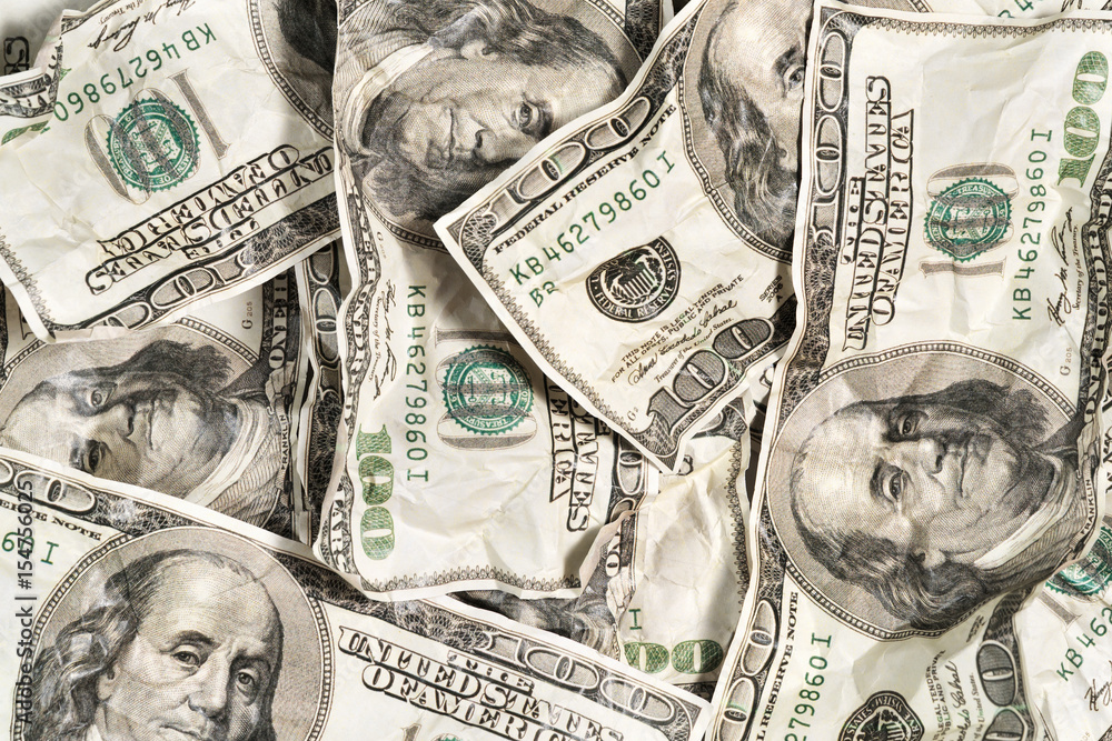 Crumpled dollars located next to each other close-up as background ...