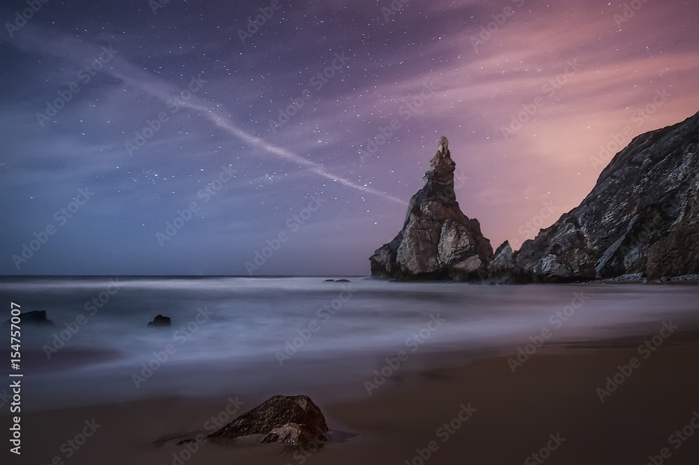 beautiful Atlantic ocean night view horizon with sandy beach and rocks ...