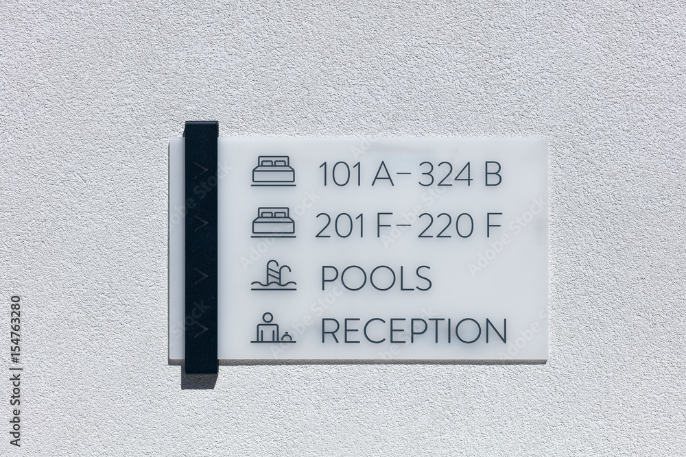 Hotel arrow signage on stone wall background. Lobby, Library ...