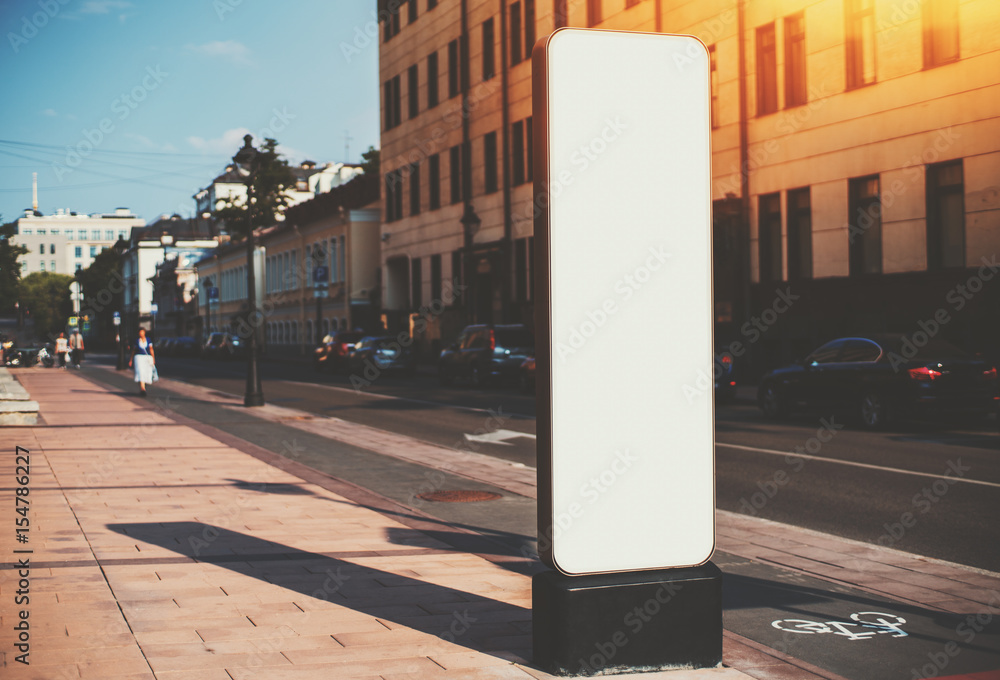 Vertical narrow information board in urban settings with road and ...