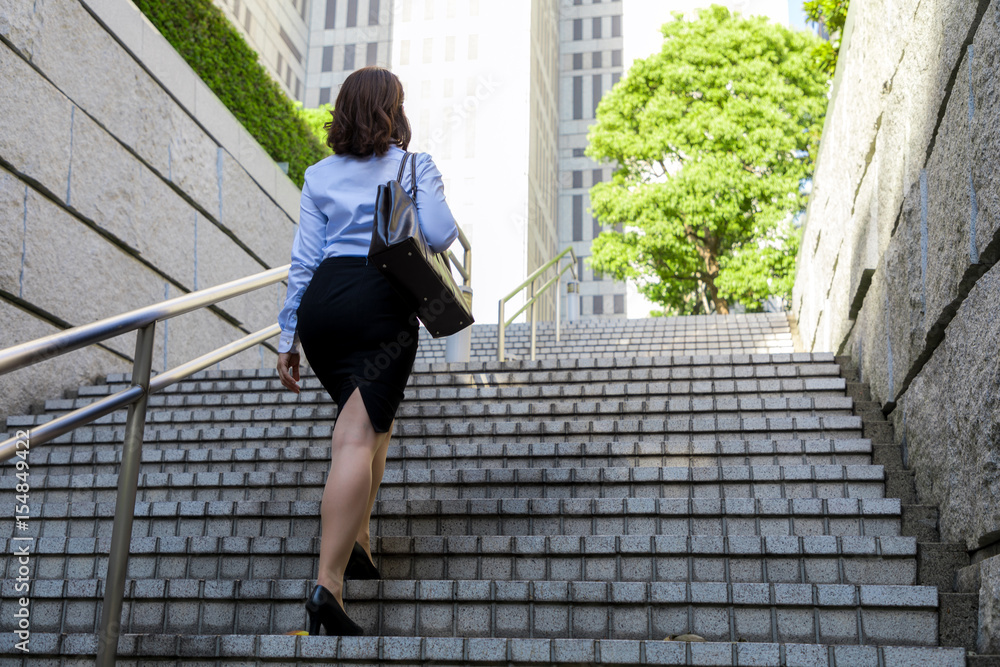 young woman going up the stairs back view. Stock-Foto | Adobe Stock