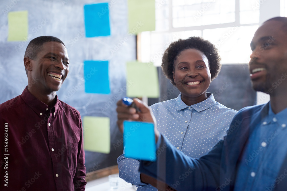 Smiling African work colleagues brainstorming in an office Stock Photo ...
