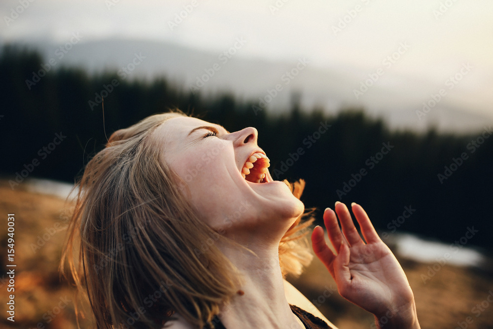 Laughing woman holds her head back posing on hill Stock Photo | Adobe Stock