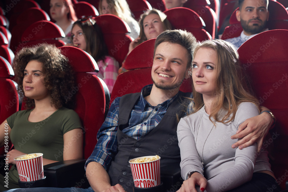 Boyfriend embracing his pretty girlfriend at cinema, when watching ...