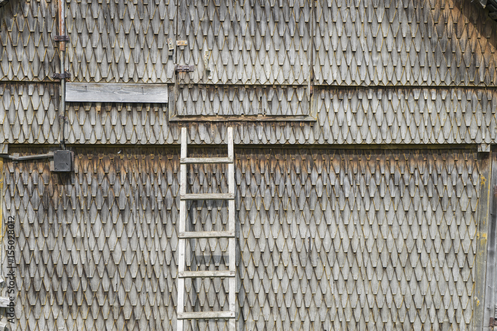 Romanian mountain village traditional wooden tile wall with a ladder ...