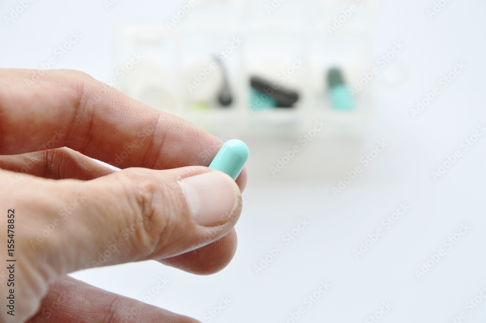 medicine capsule picking in human finger with drug box background Stock ...