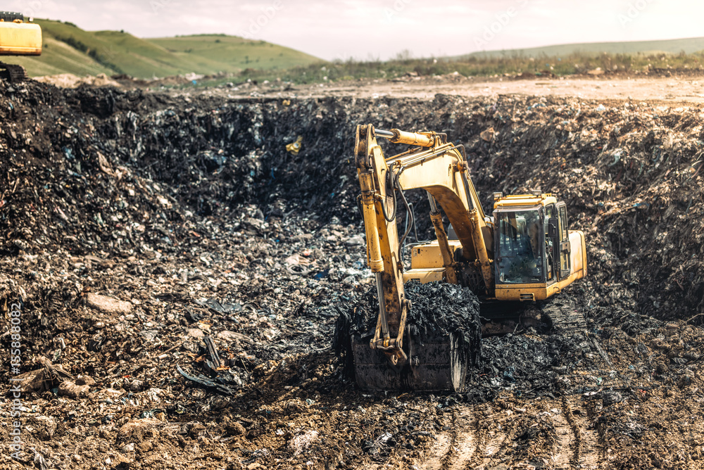 Heavy duty excavator loader, bulldozer working in garbage dump ...