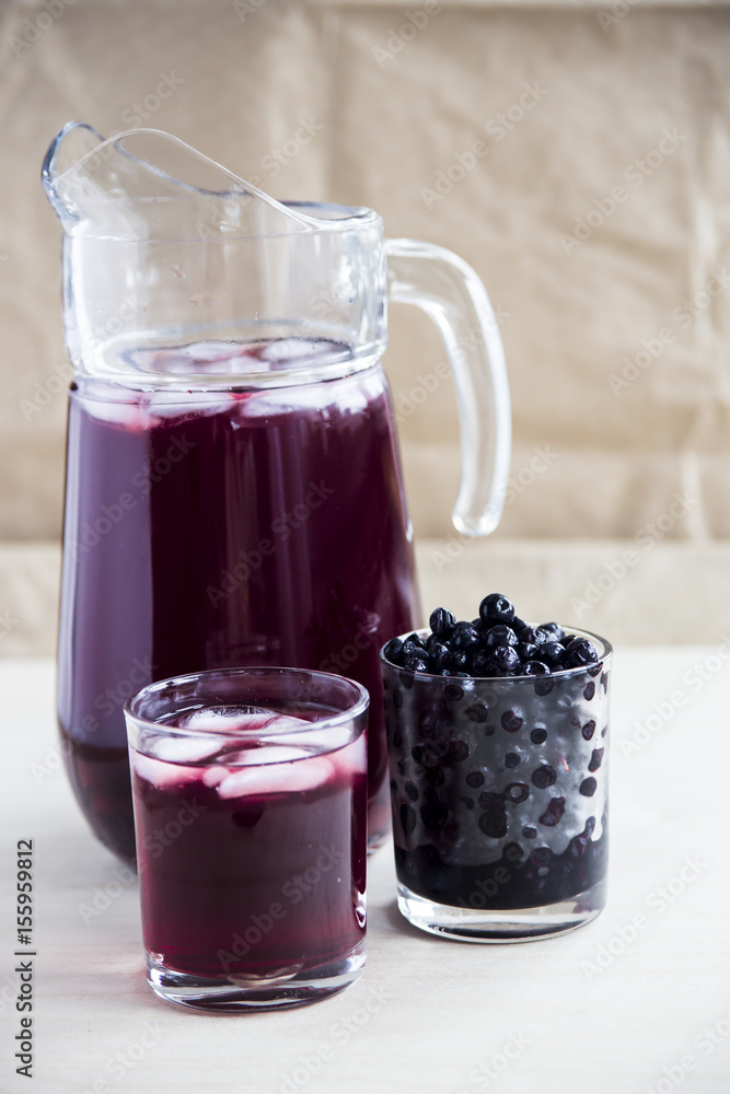 Blueberry juice in a decanter and a glass next to frozen berries Stock ...