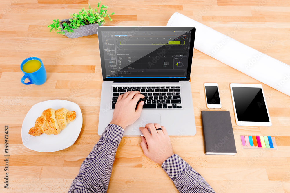 Software engineer's workplace with laptop, tablet, sketching ...