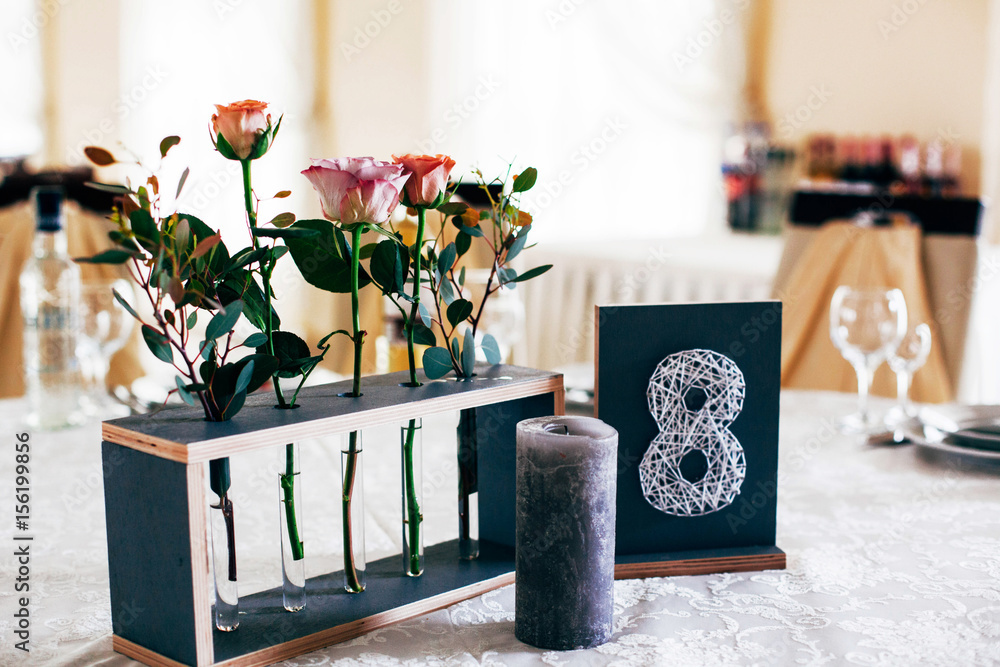Number eight written on black board stands before board with roses in ...