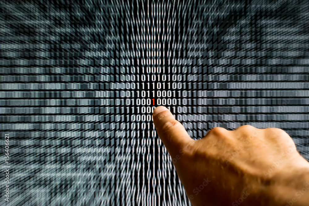 Finger pointing at a red bit in binary code Stock Photo | Adobe Stock