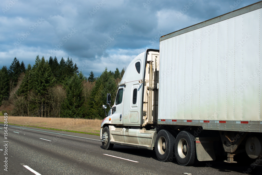 Dirty modern semi truck big rig trailer dry van on straight highway ...