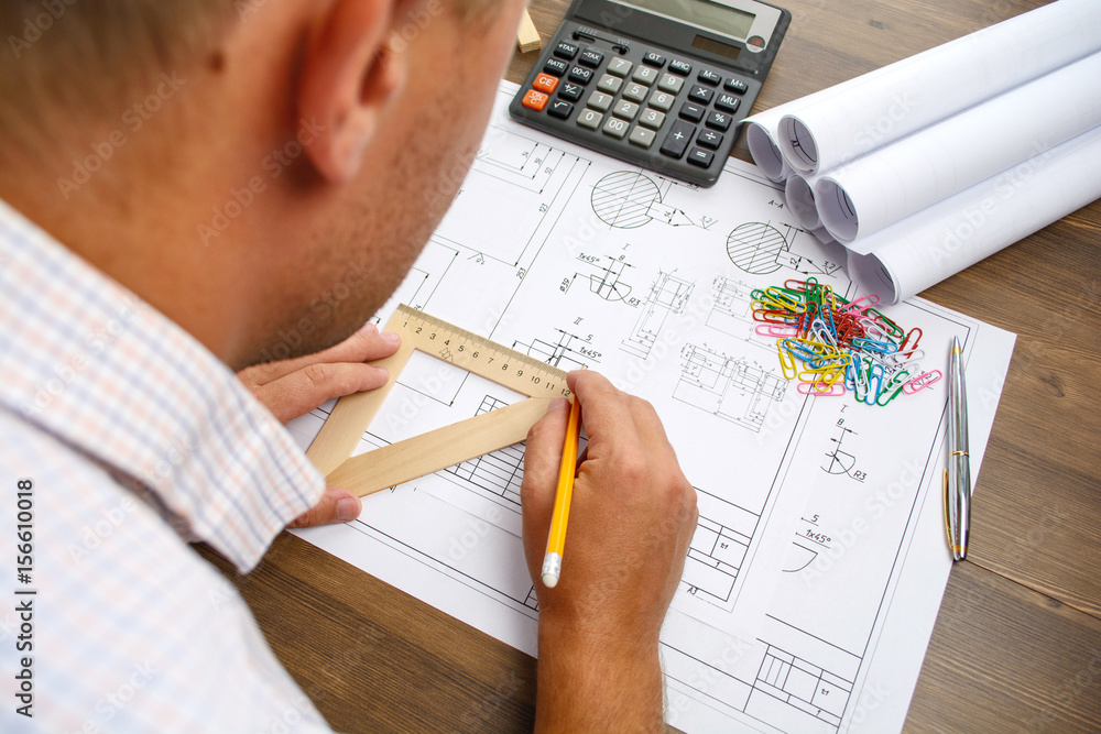 Mechanical engineer at work. Technical drawings. Paper with technical ...