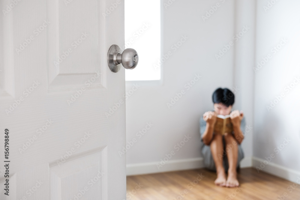 Door opened with blur nerd Asian guy reading a book in corner of the ...