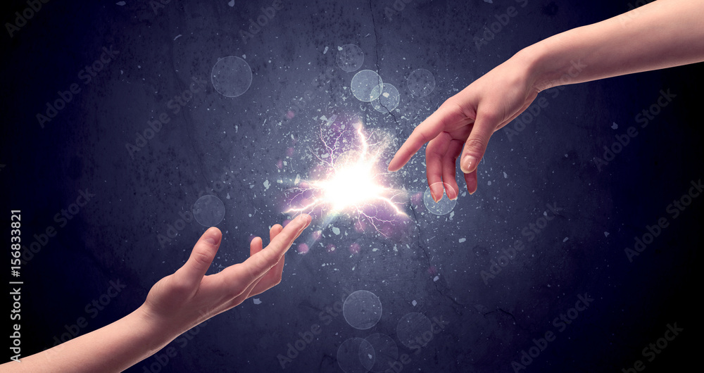 Hands reaching to light a spark Stock Photo | Adobe Stock
