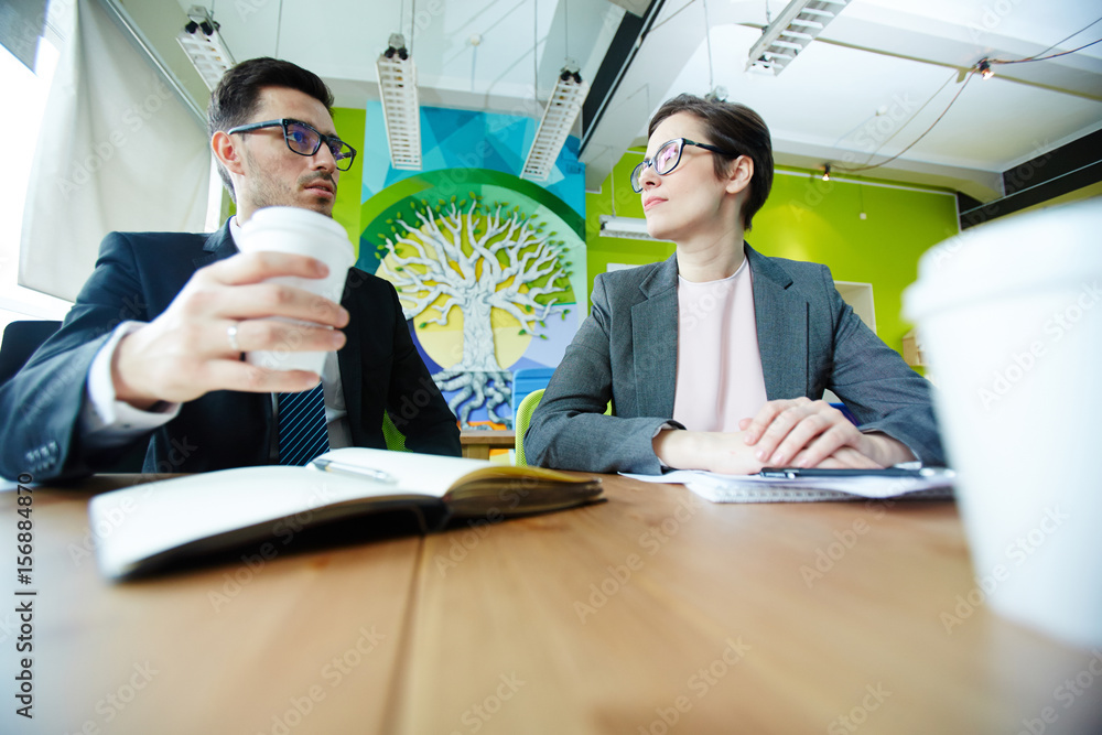 Low angle shot of two business partners man and woman discussing work ...