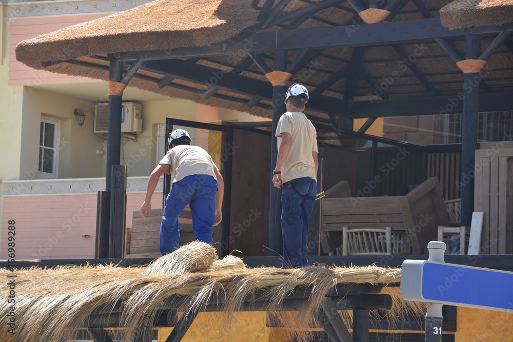 obreros reparando un tejado de paja Stock Photo | Adobe Stock