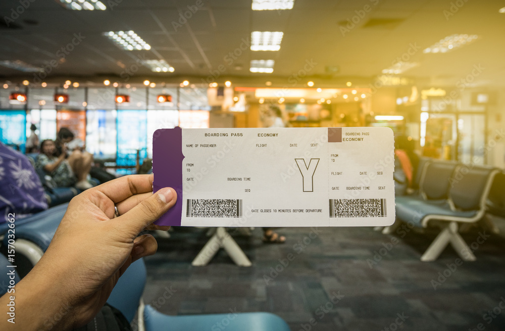 Boarding pass on hand with blur airport terminal background in traveler ...